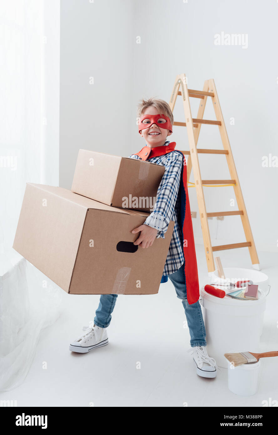 Cute superhero boy with mask and cape, he is carrying easily heavy ...