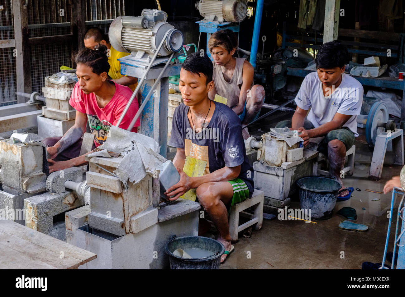 Workers are cutting precious jade stones into small pieces in the jade ...