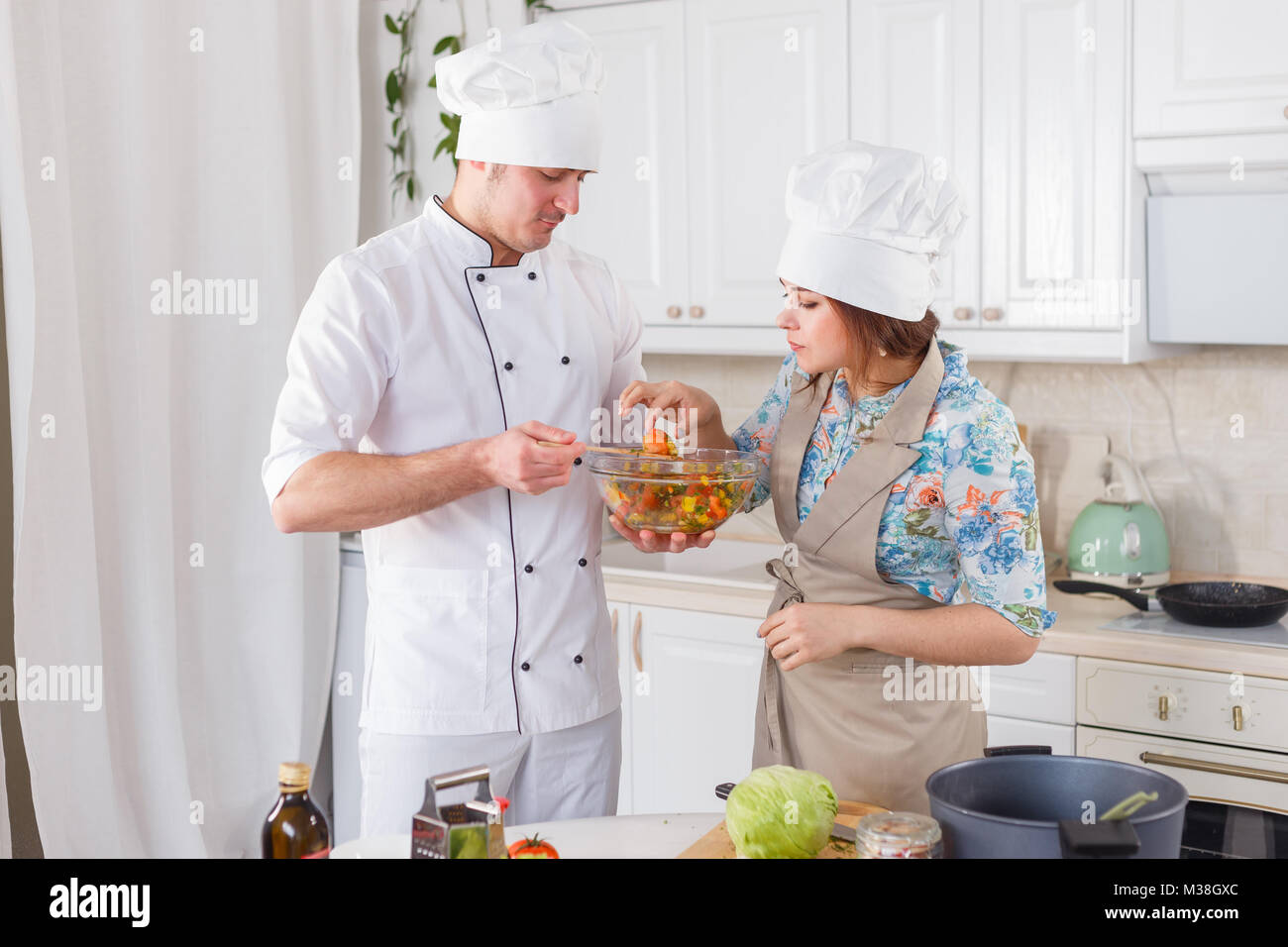 Cook in uniform and his apprentice cooking vegetarian meal Stock Photo ...