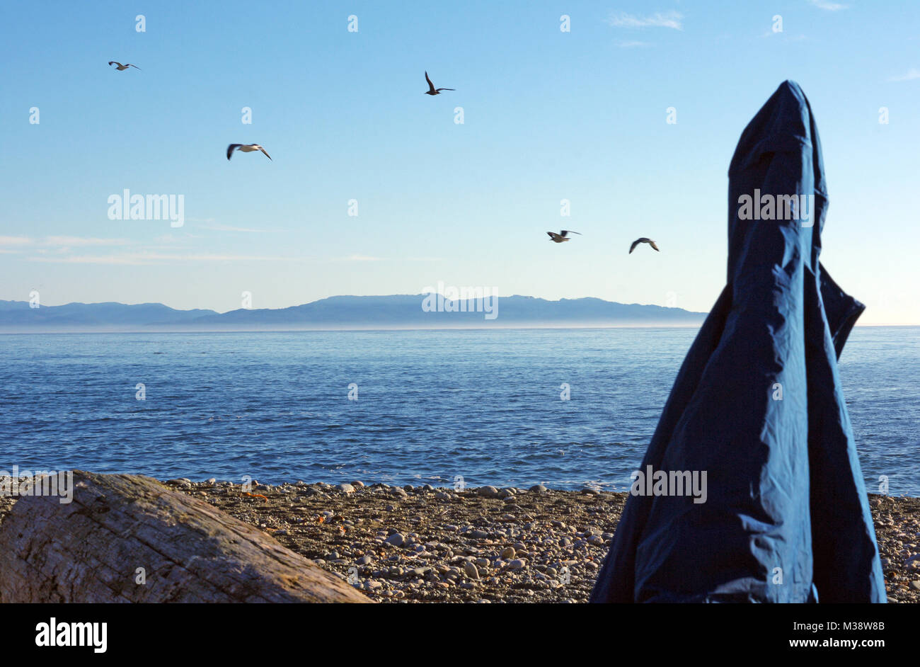 Blue weatherproof jacket hanging by ocean Stock Photo - Alamy