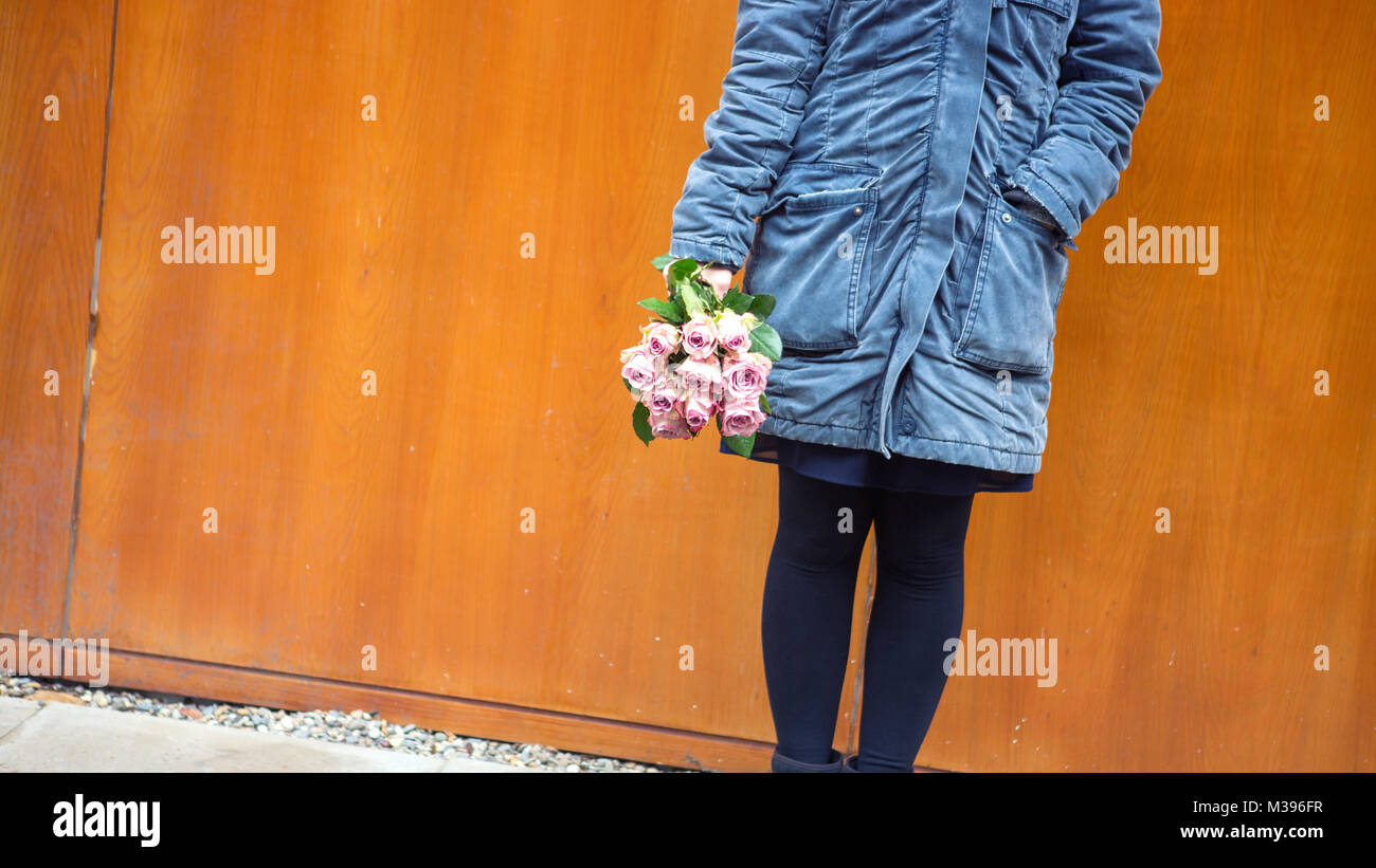 young woman standing outside in the cold with bouquet of roses Stock ...