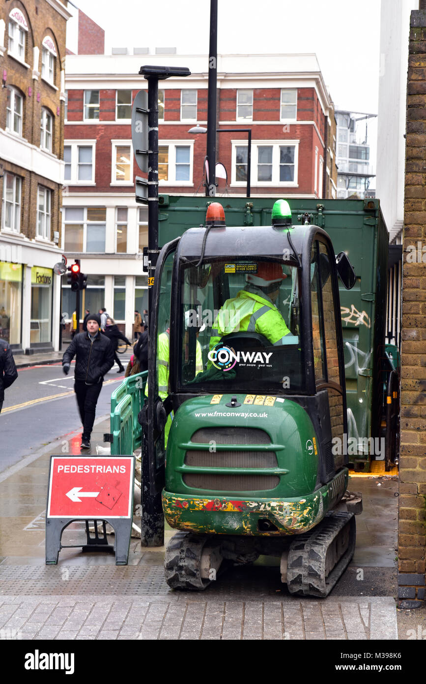 Men at work on a busy london or inner city urban street digging a hole ...