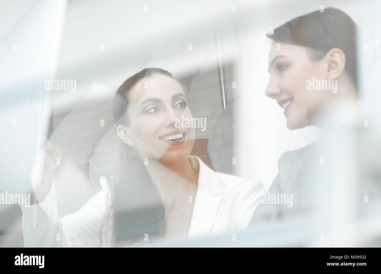 behind the glass.colleagues sitting at your Desk Stock Photo - Alamy