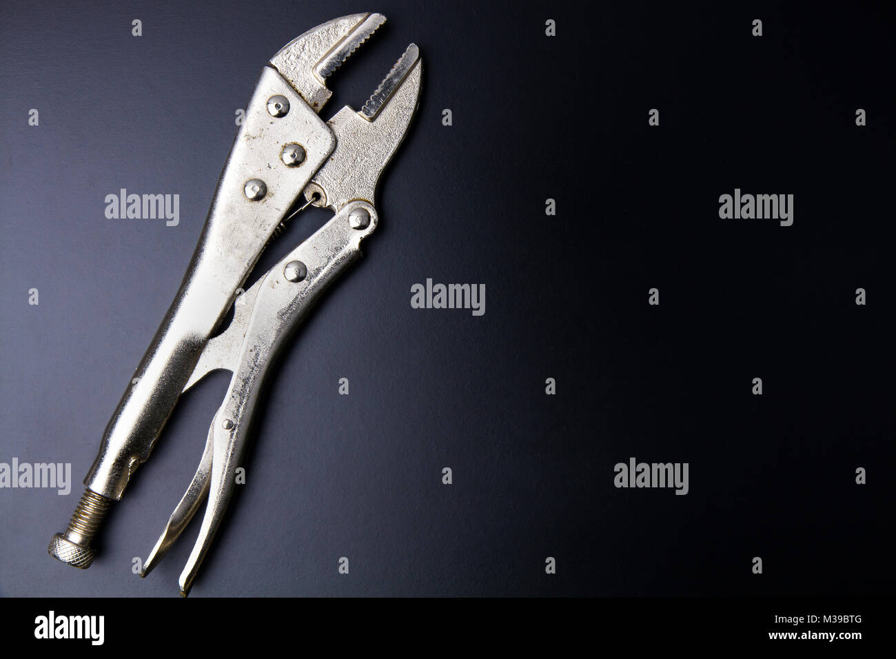 Locking wrench construction tools on a black background with light copy ...