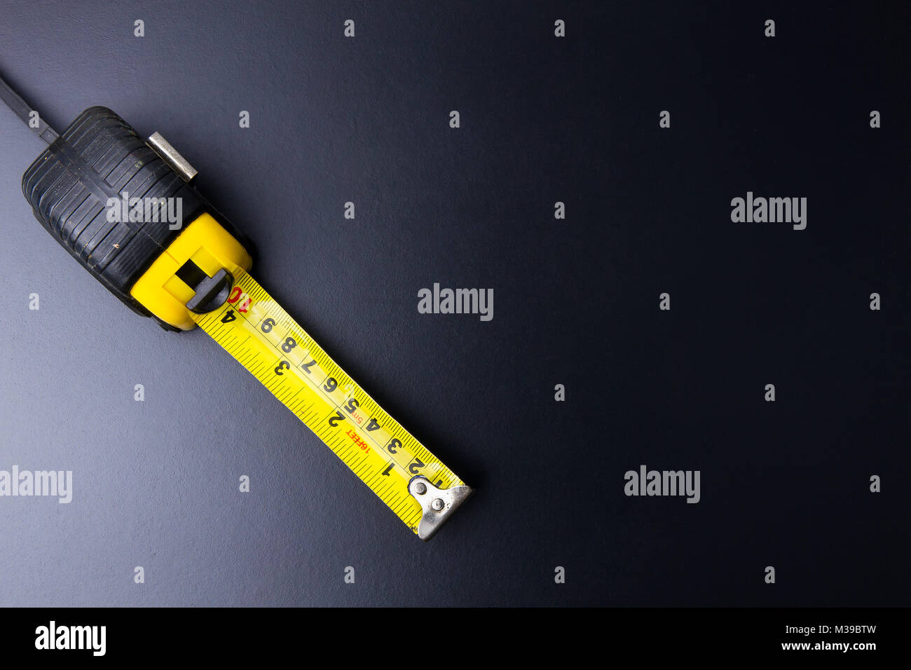 Measuring Tape construction tools on a black background with light copy ...