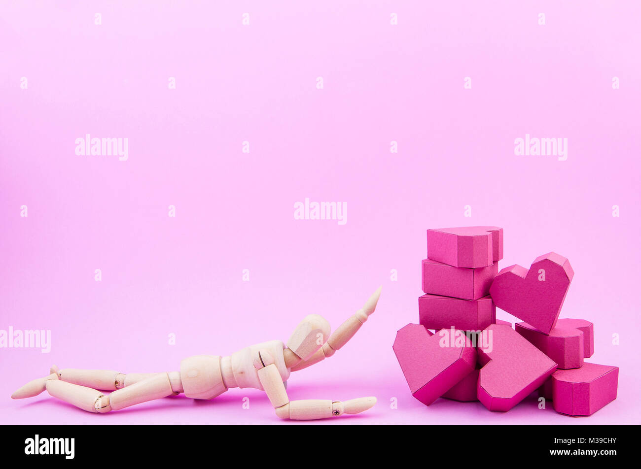 Wooden dummy was crawling to a pile of paper box red heart shape on ...