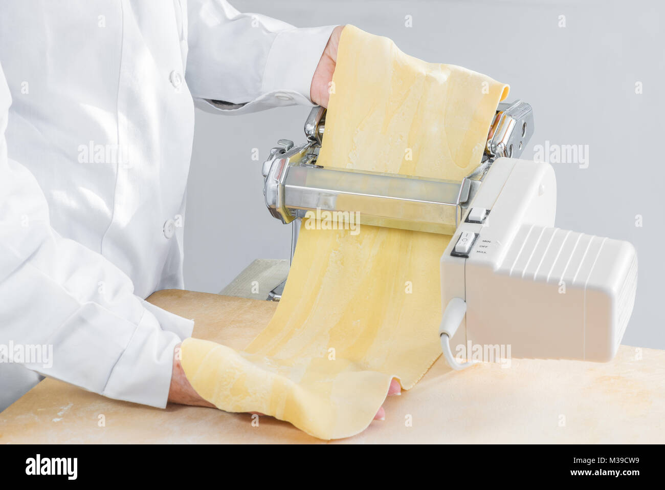 Person rolling dough through machine hi-res stock photography and ...