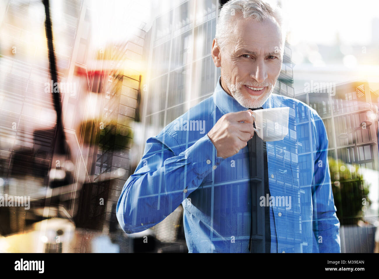 Smiling man being in a good mood while drinking coffee Stock Photo - Alamy
