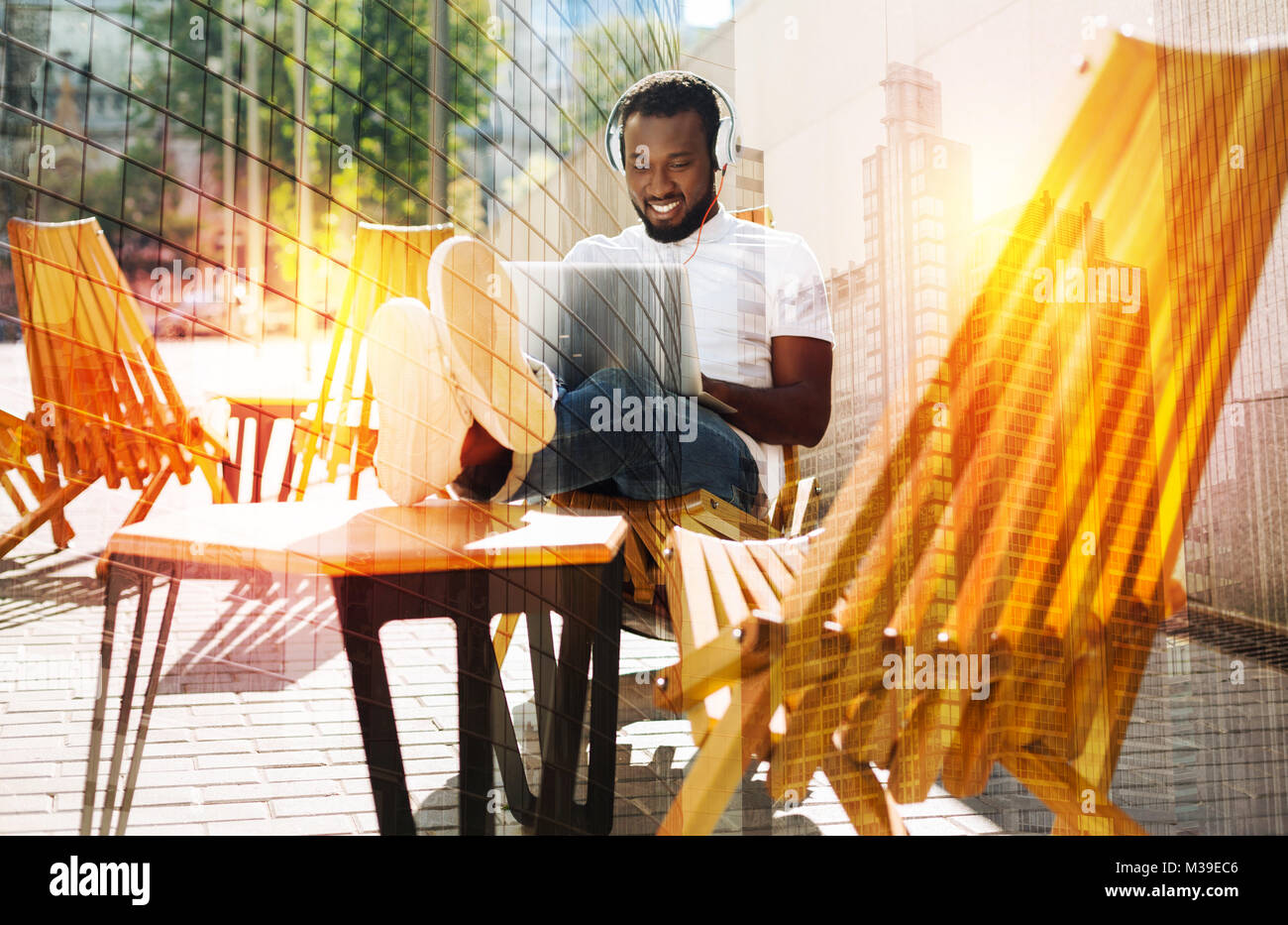 Positive person smiling while listening to music in big headphones ...