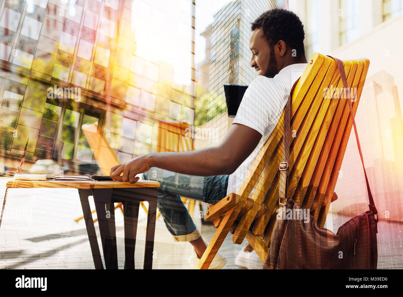 Relaxing young man feeling good and sitting in an armchair while ...