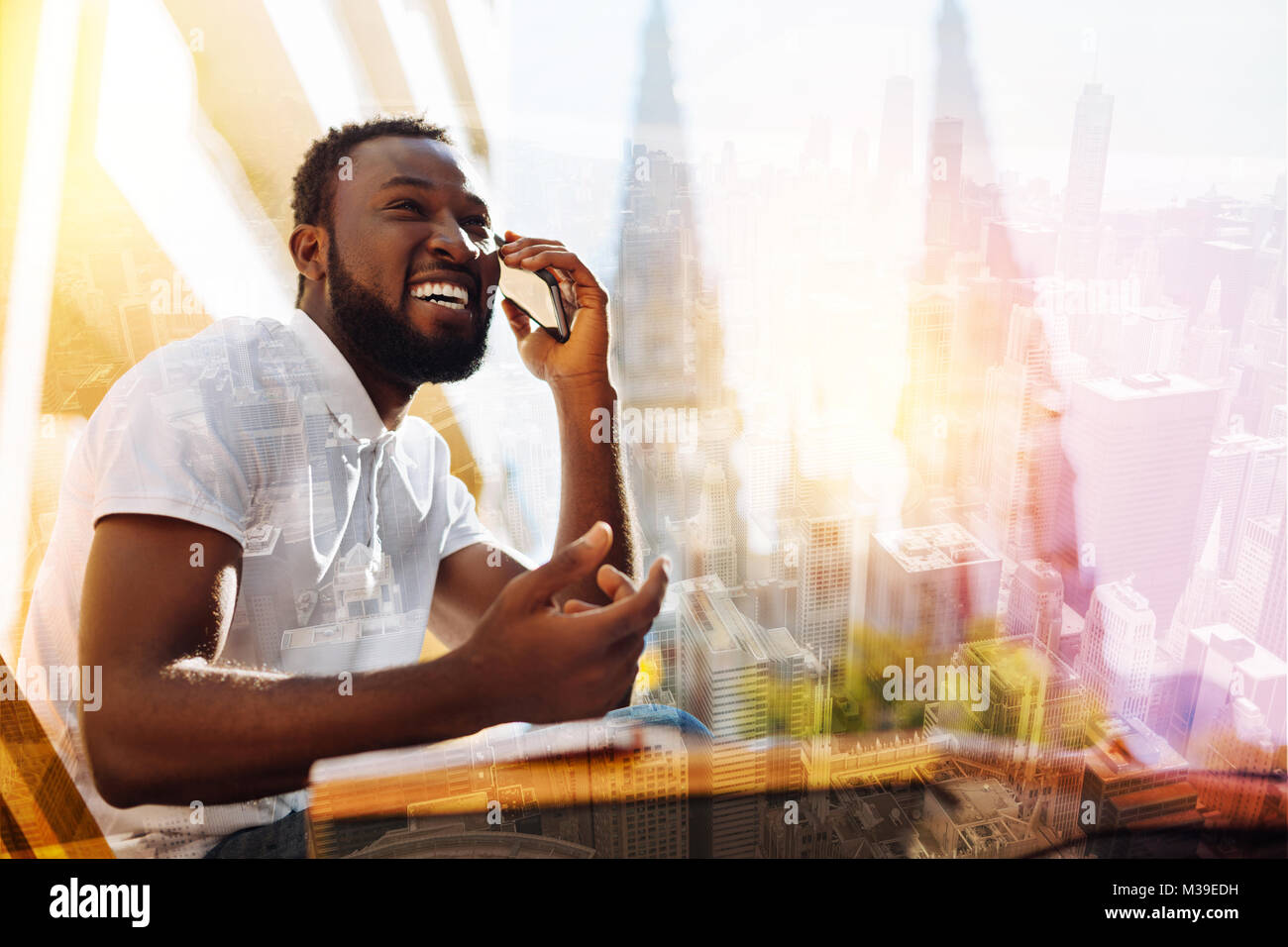 Emotional man laughing while talking on the phone with parents Stock ...