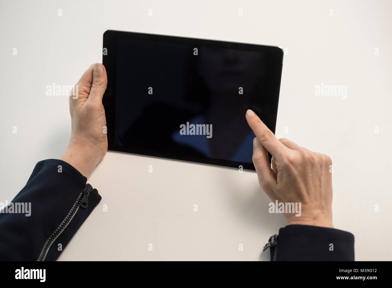 male and female mens and womens hands using an ipad computer tablet for ...