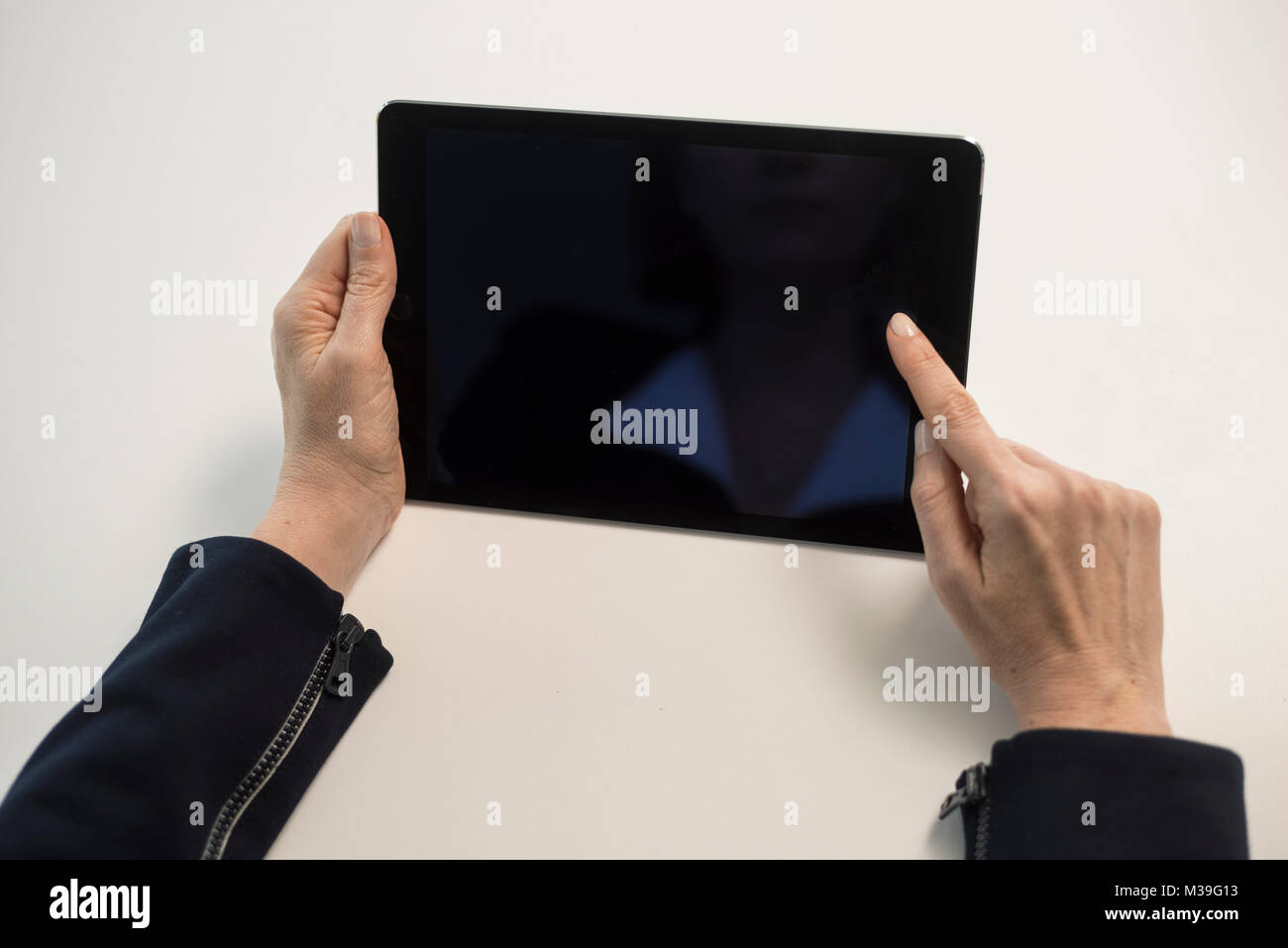 male and female mens and womens hands using an ipad computer tablet for ...