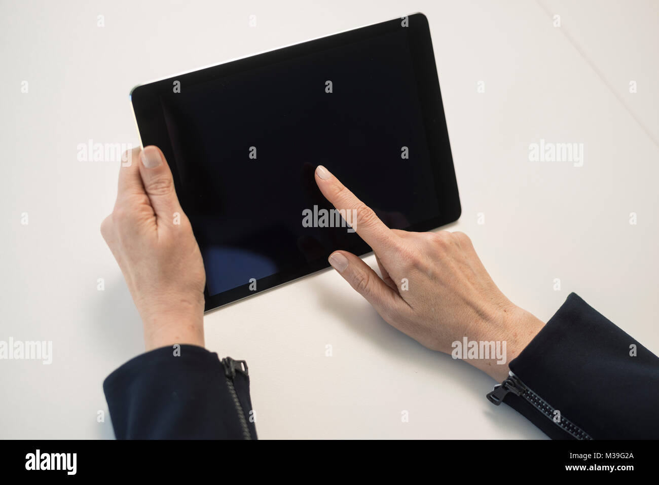 male and female mens and womens hands using an ipad computer tablet for ...