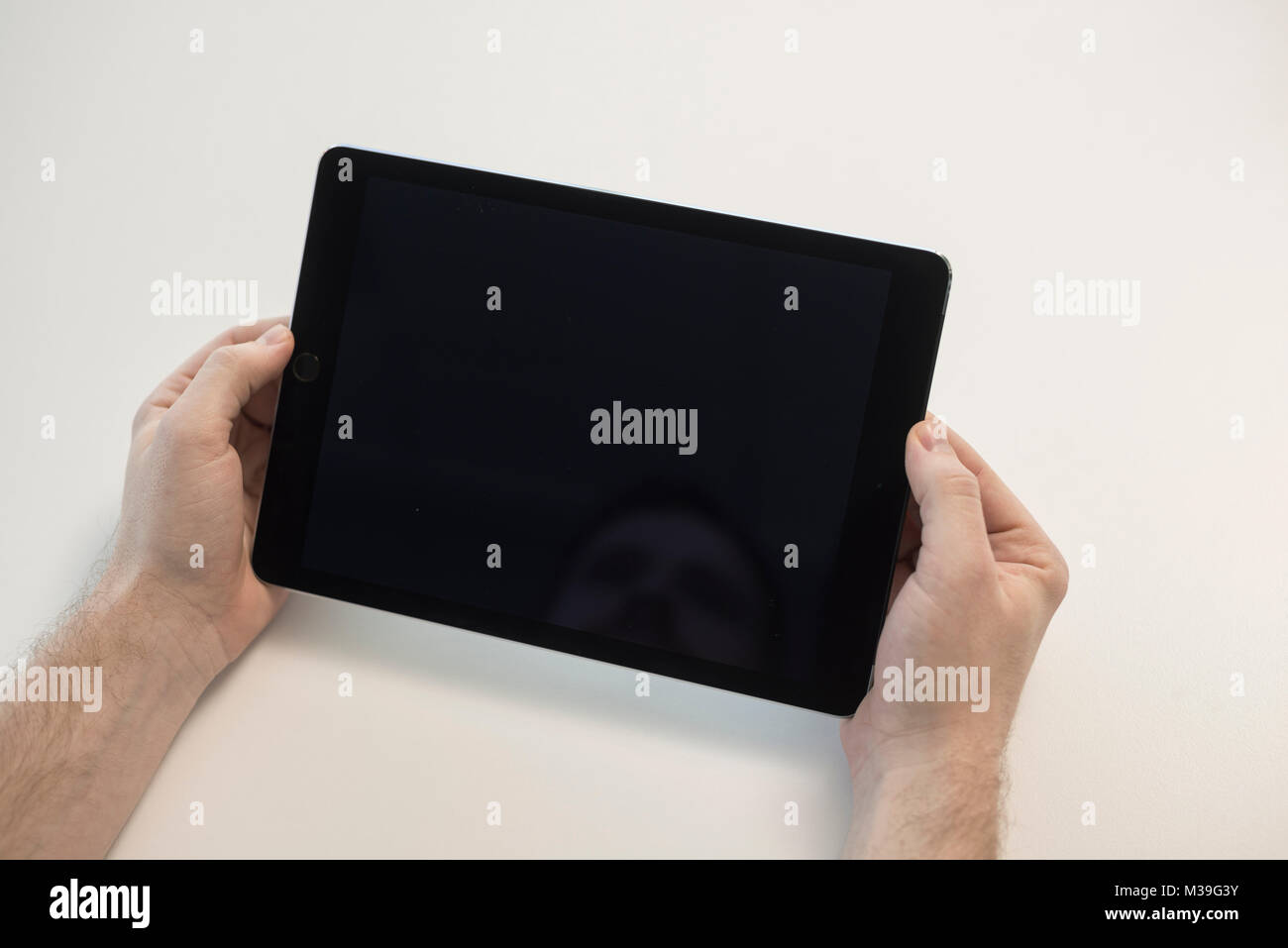 male and female mens and womens hands using an ipad computer tablet for ...