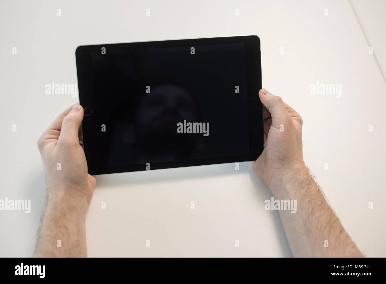 male and female mens and womens hands using an ipad computer tablet for ...