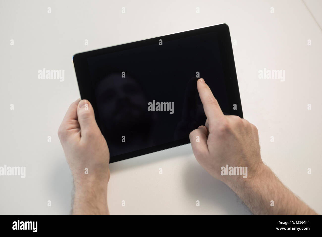 male and female mens and womens hands using an ipad computer tablet for ...