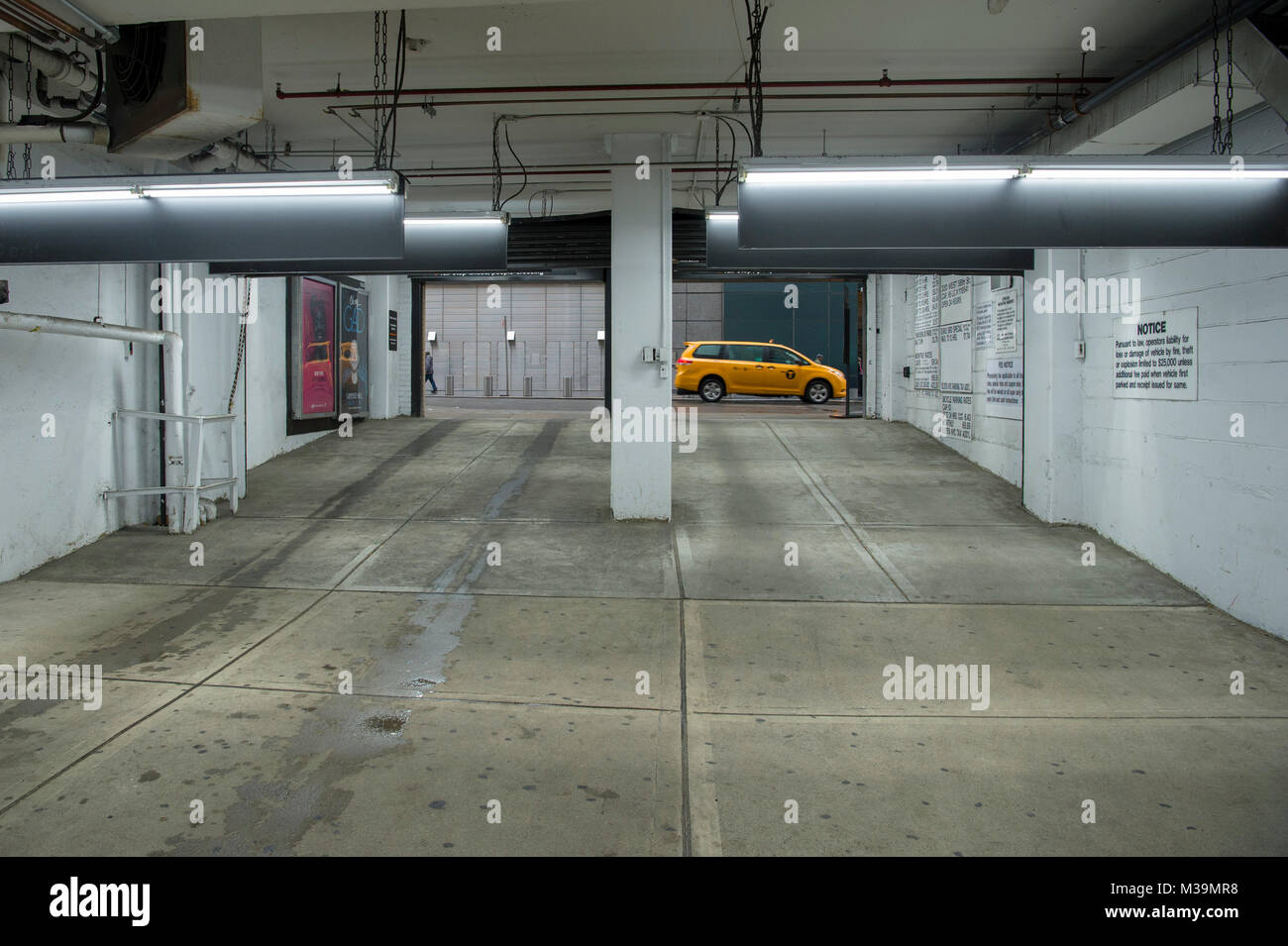 Yellow taxi passes car park entrance. Manhattan, New York Stock Photo ...