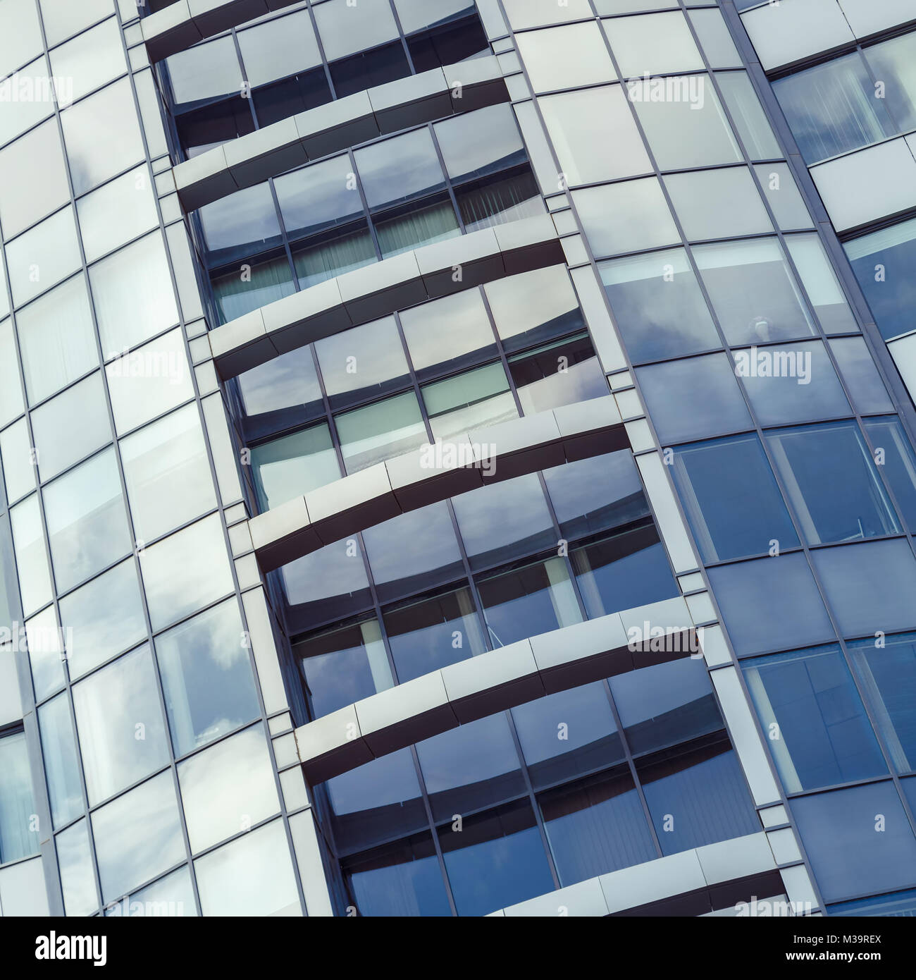 Facade part of a modern high-rise building and the reflection of clouds ...