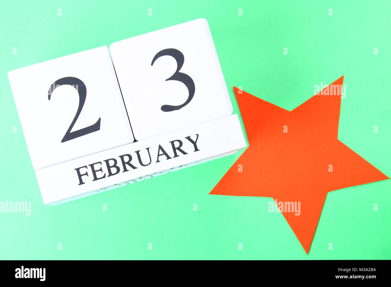 White wooden perpetual calendar with the date of February 23 on a green ...