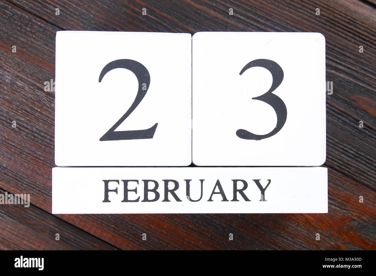 White wooden perpetual calendar with the date of February 23 on a ...