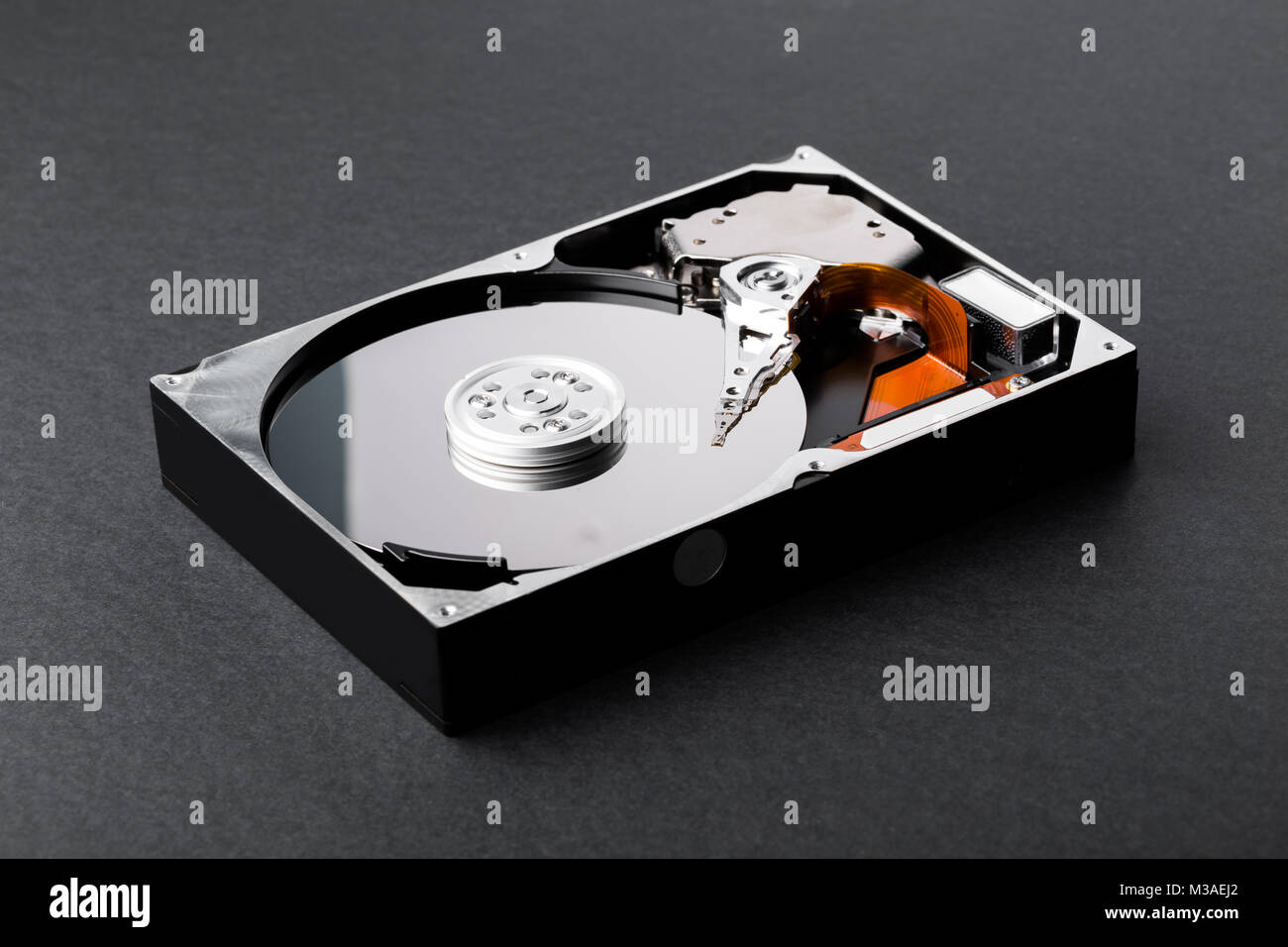Open disassembled hard disk on black plastic background Stock Photo - Alamy