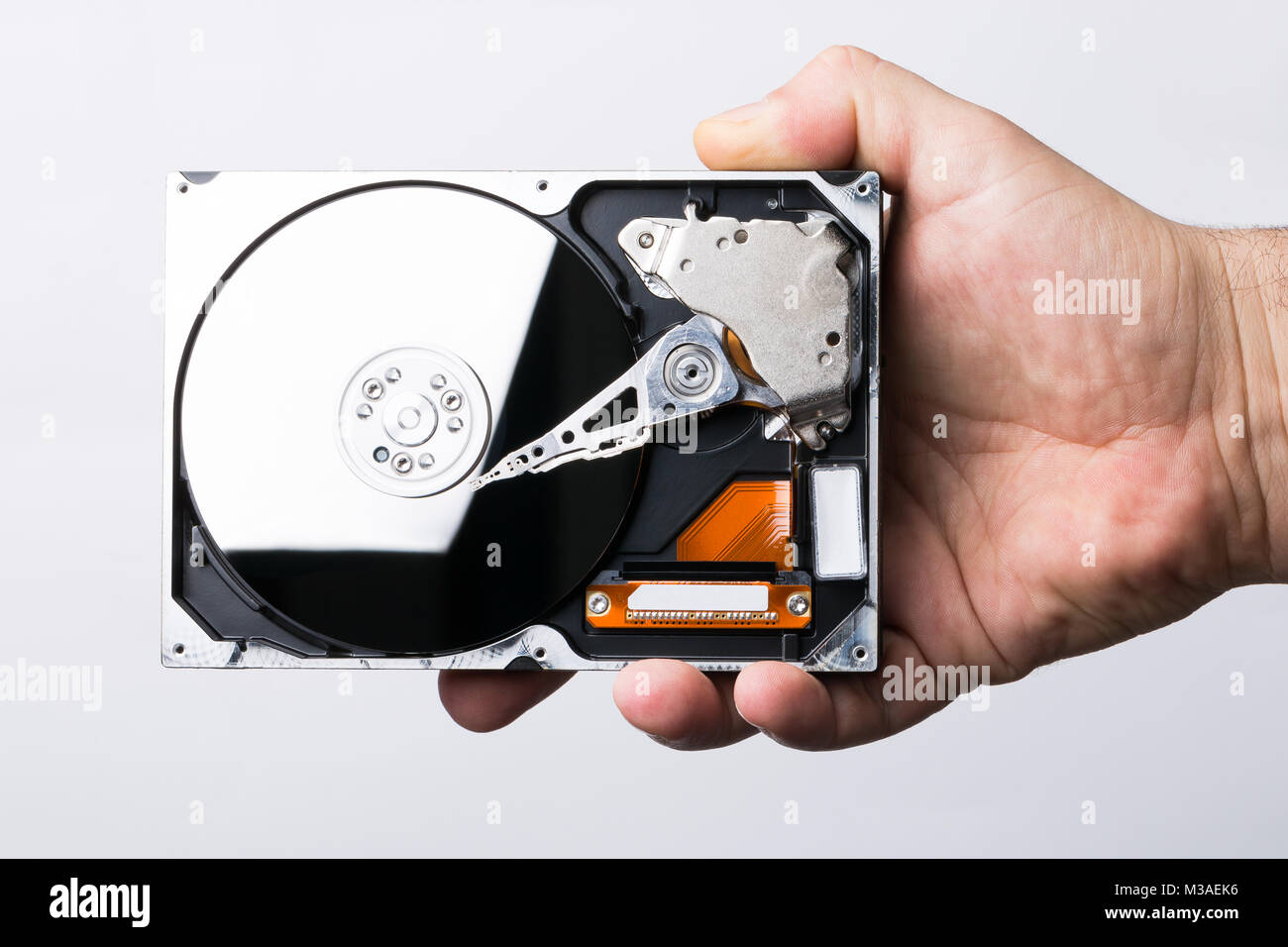 Male technician hand holding computer hard drive over white background ...