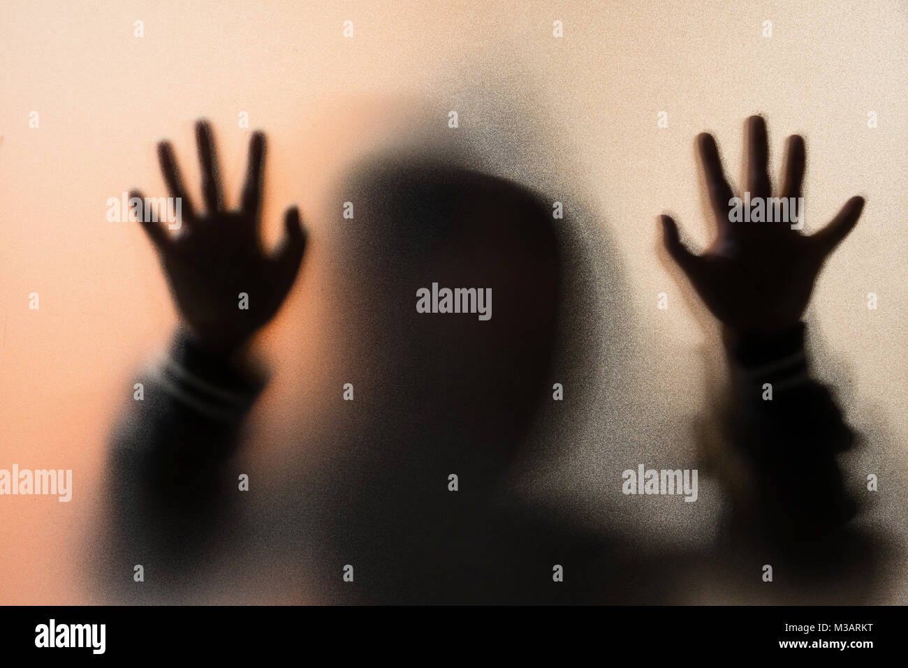 Shadow blur of horror man in jacket with hood.Hands on the glass ...