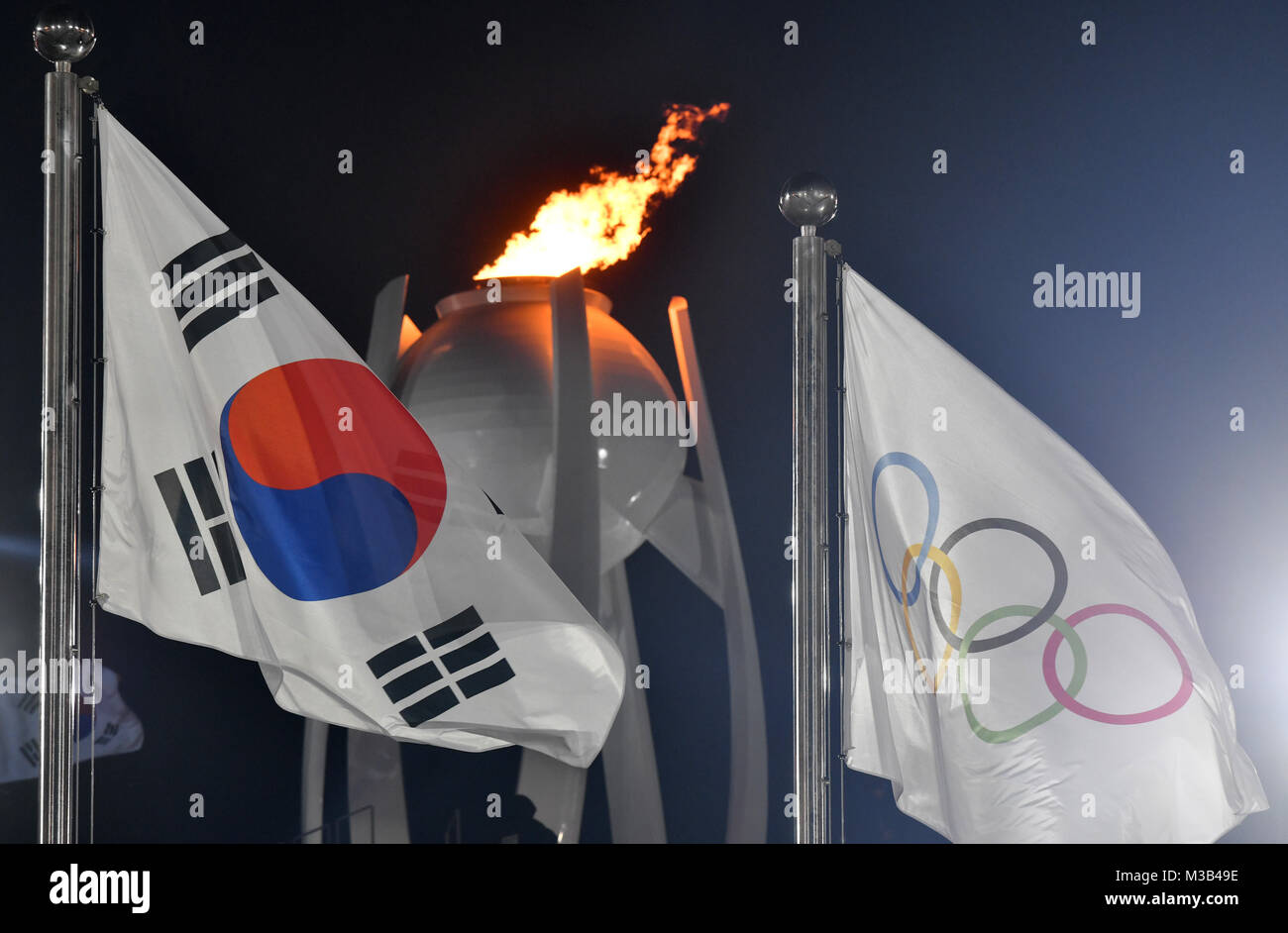 Pyeongchang, South Korea. 9th Feb, 2018. The Olympic flame burns behind ...