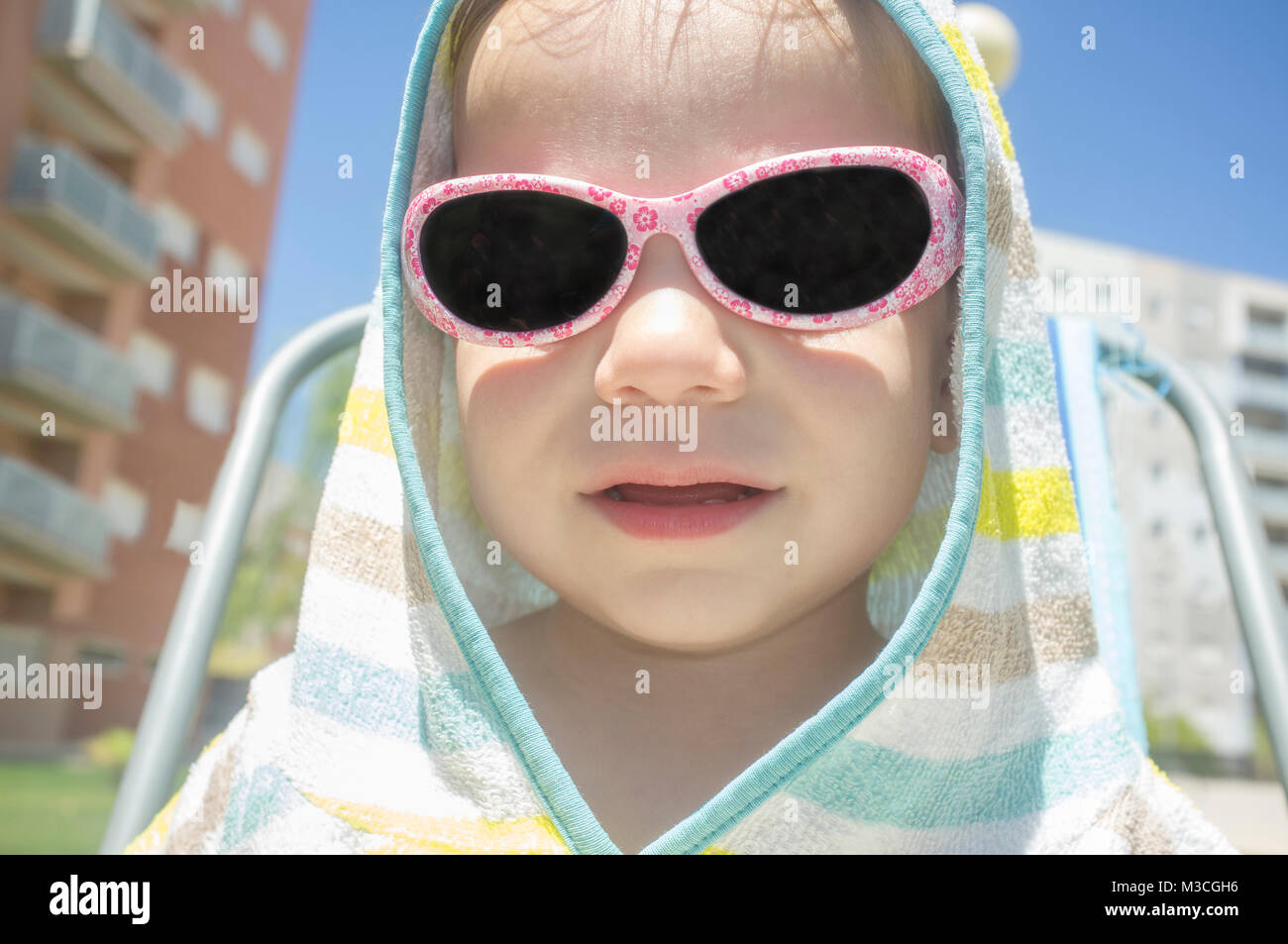 2 Year Baby Boy With Hooded Poncho Towel After Swimming He Is Sitting 2-year-baby-boy-with-hooded-poncho-towel-after-swimming-he-is-sitting