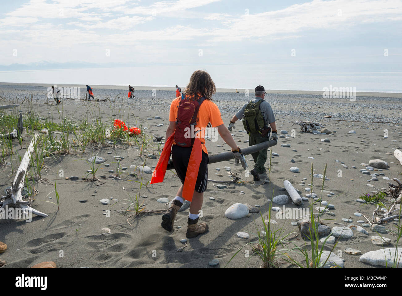 NPS Law Enforcement Ranger Mike helps a youth volunteer carry marine ...