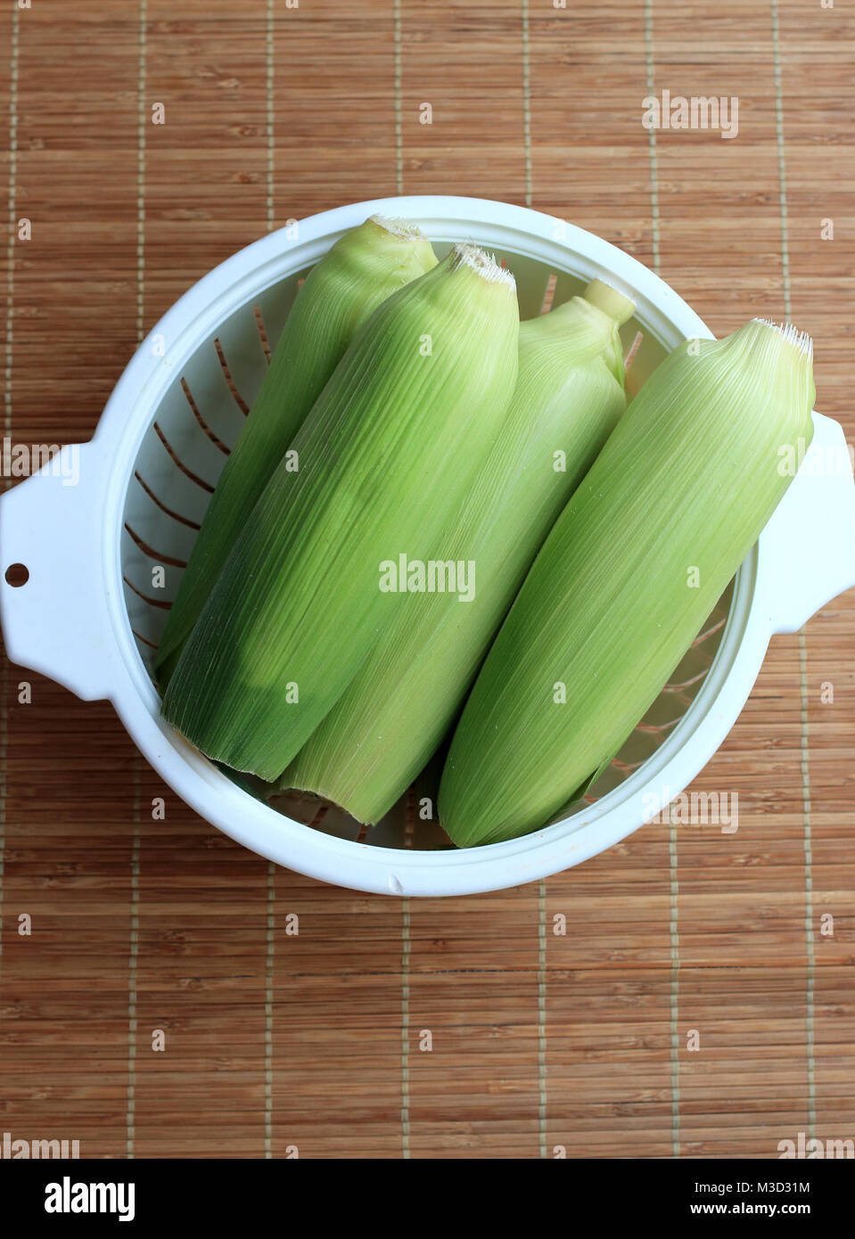 Fresh corn in white plastic colander Stock Photo - Alamy