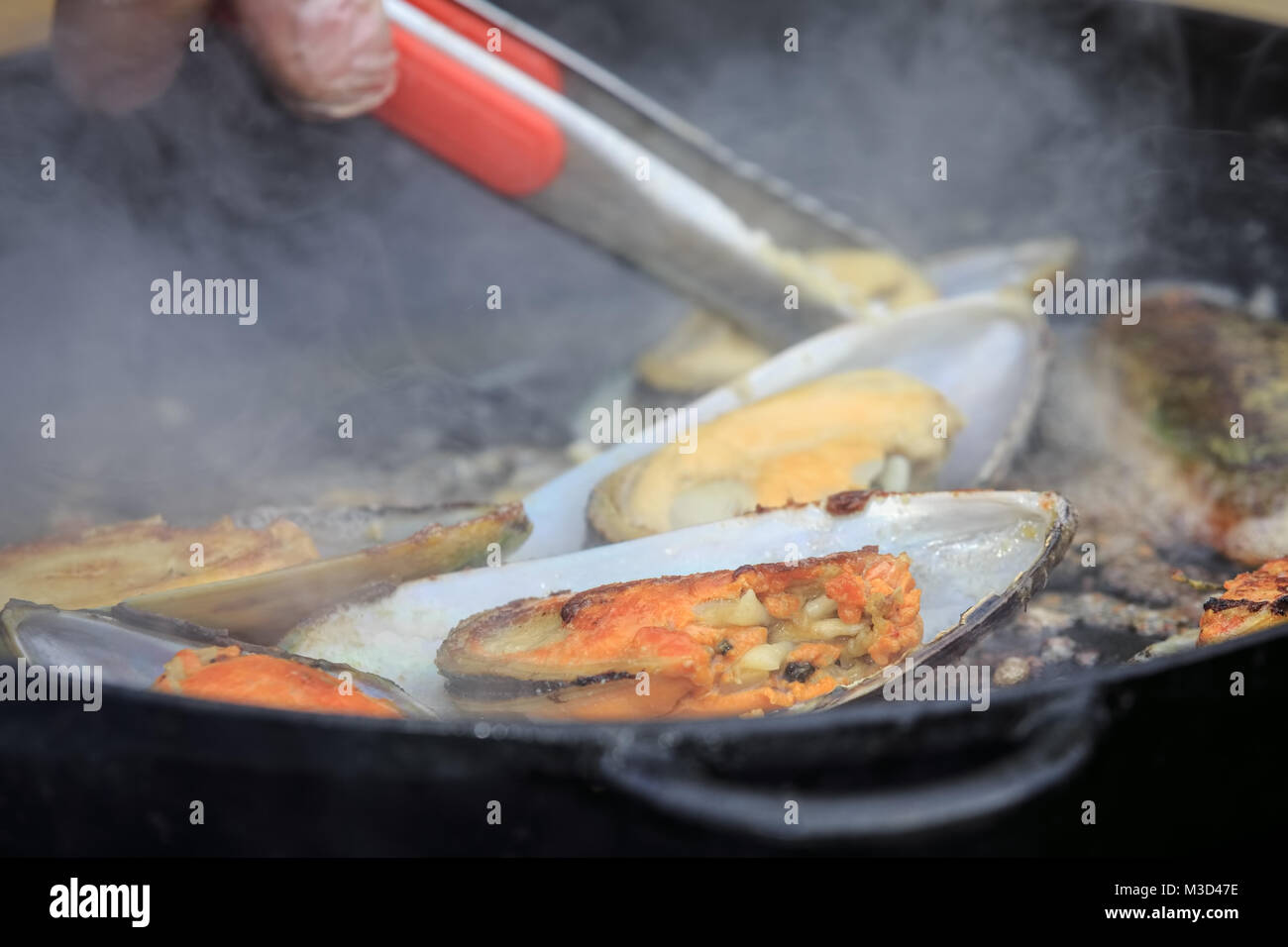 The process of cooking fried mussels in a frying pan Stock Photo - Alamy