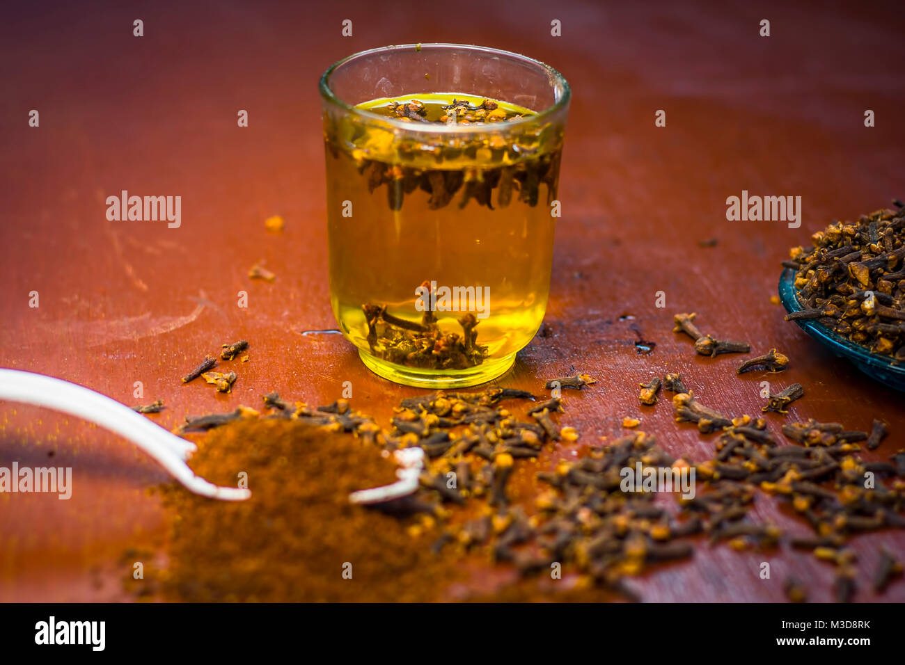 Close up of cloves,Syzygium aromaticum in a plate with its powder in a ...