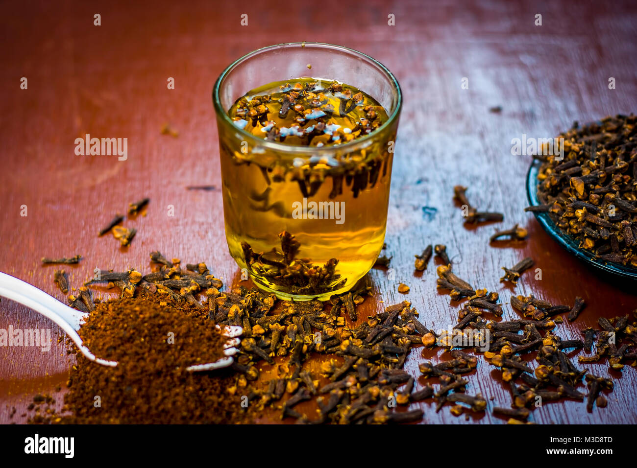 Close up of cloves,Syzygium aromaticum in a plate with its powder in a ...