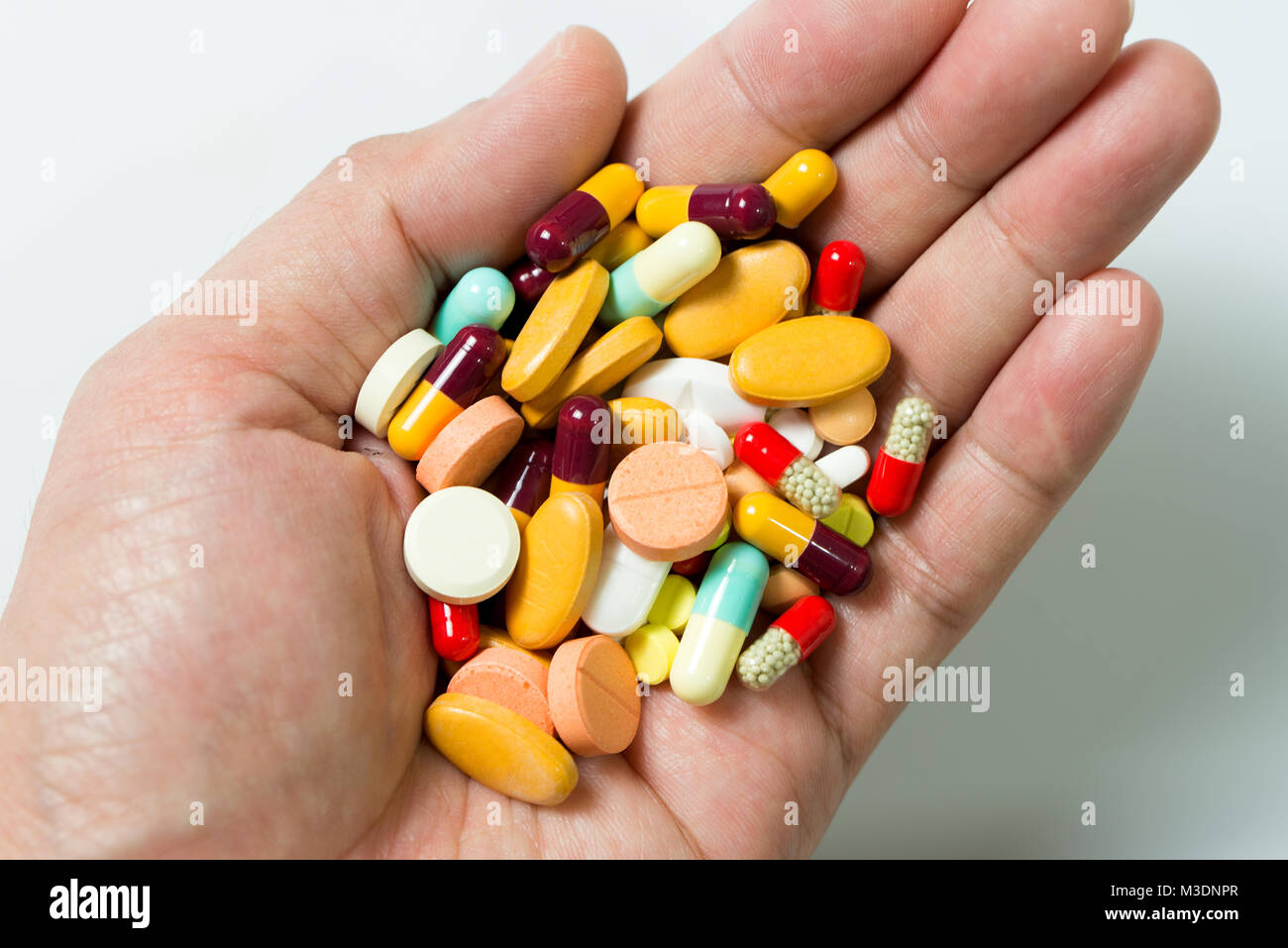 Hand full of pills Stock Photo - Alamy