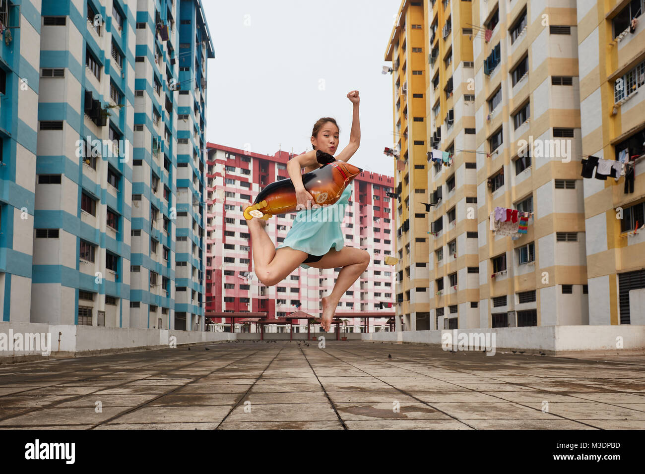 Happy, free, young female dancer at Rochor Center, Singapore. Building ...