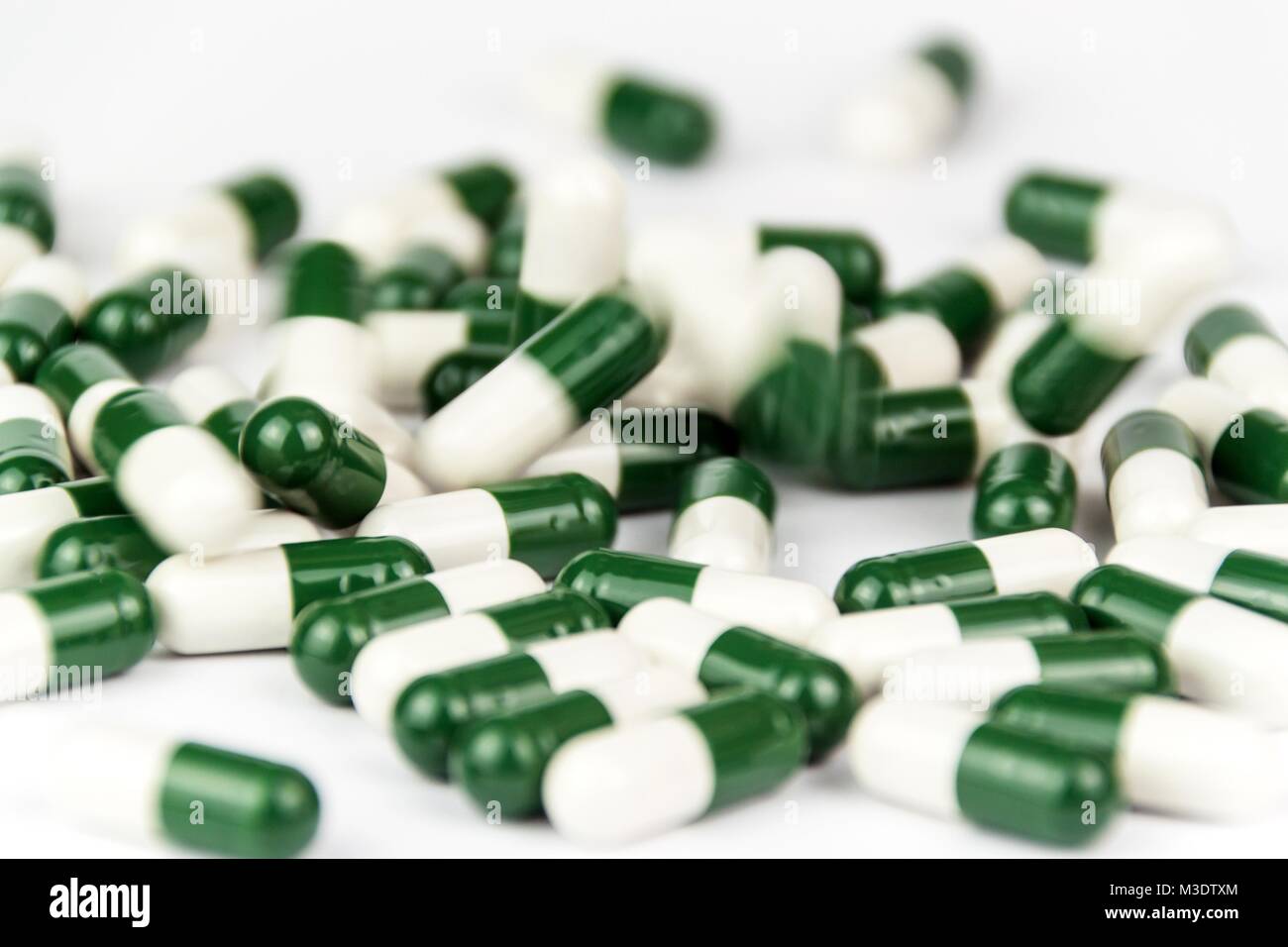 green-white pills on a white background. Pharmaceutical industry ...