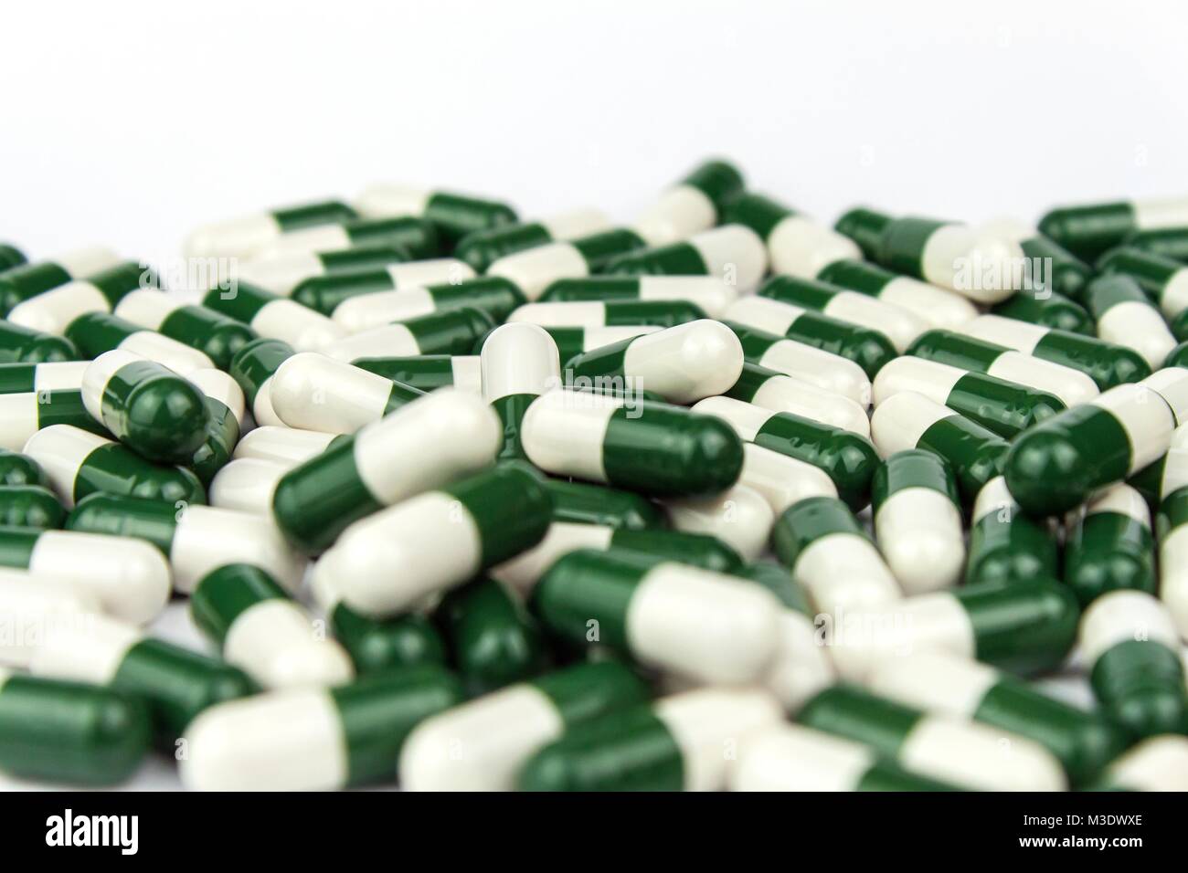 green-white pills on a white background. Pharmaceutical industry ...