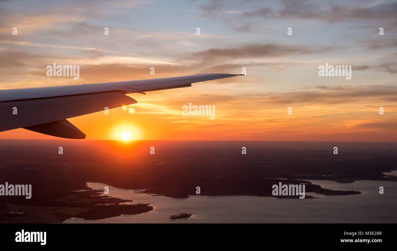 Sunset Outside of Airplane Window with Boat on Water Stock Photo - Alamy