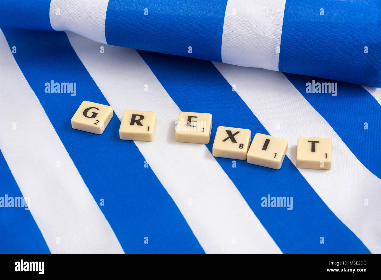 Greek flag and alphabet tiles spelling GREXIT Stock Photo - Alamy