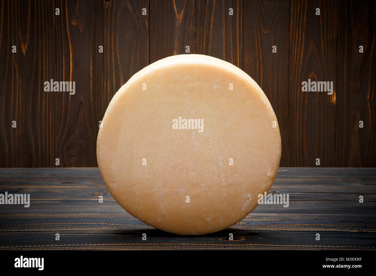 Whole round Head of parmesan or parmigiano hard cheese on wooden ...
