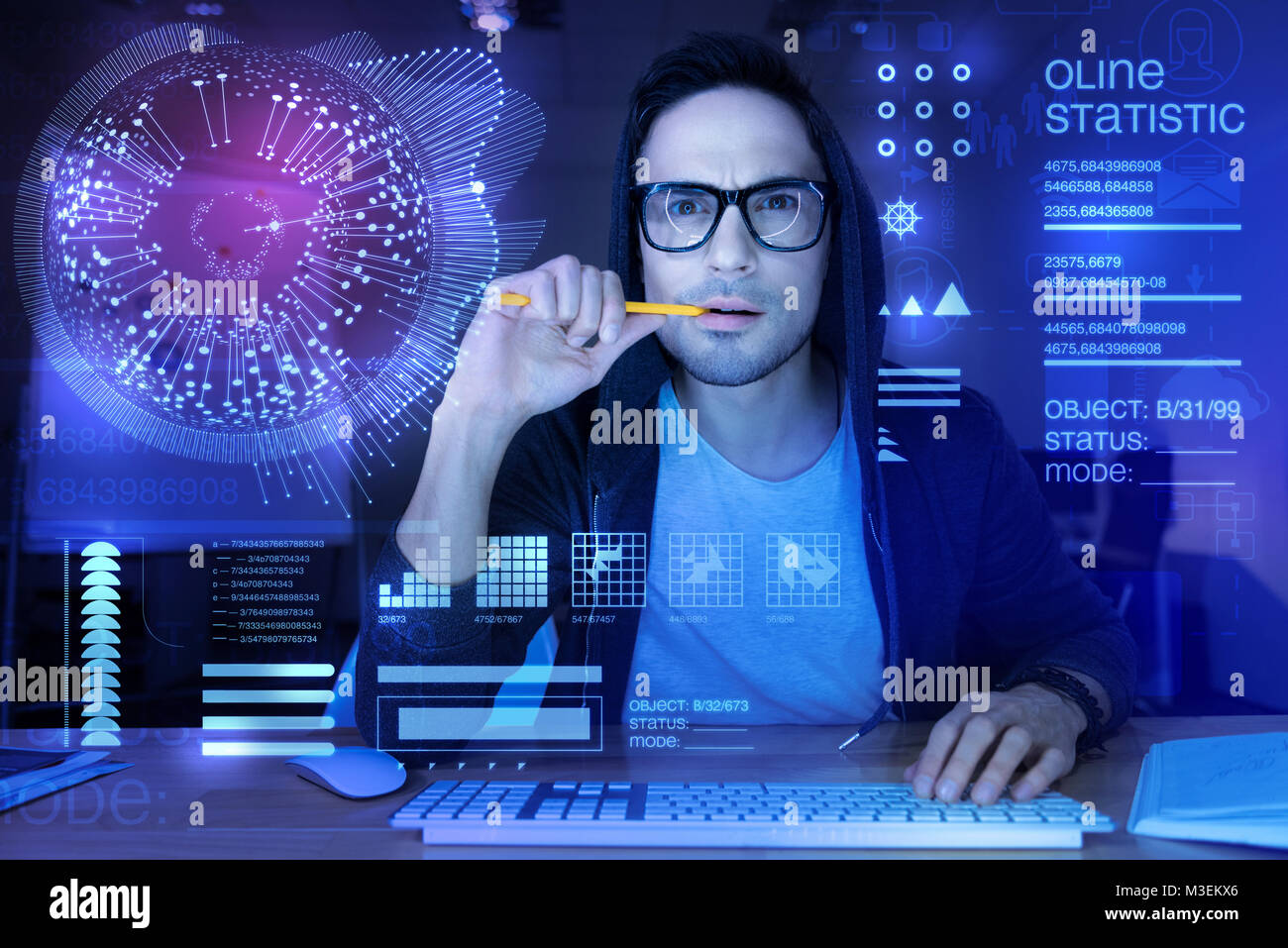 Handsome programmer frowning and biting a pencil while thinking Stock ...