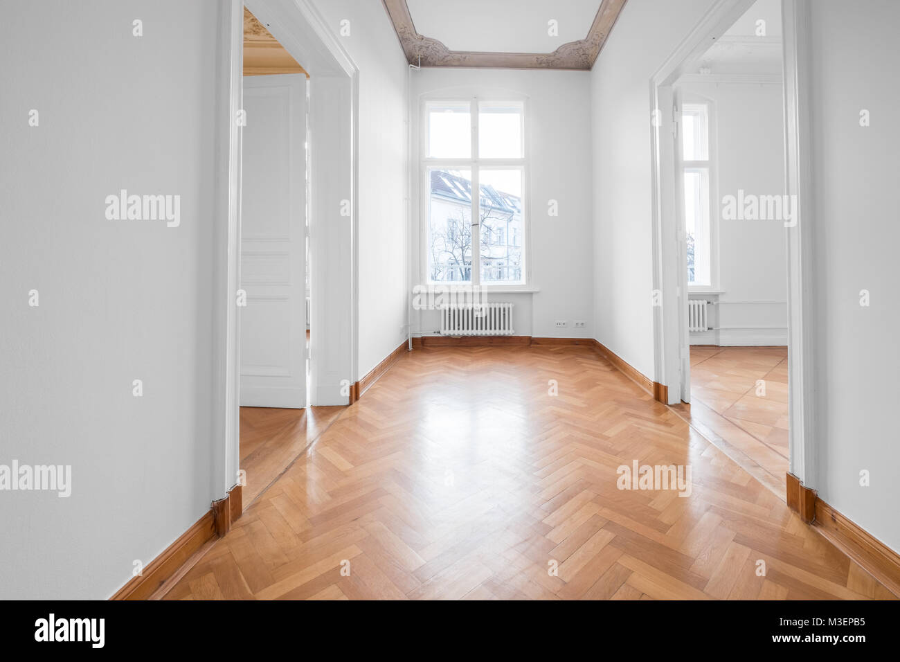 renovated old building room, flat with stucco ceiling and parquet floor ...
