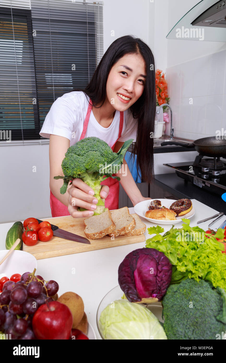 woman holding green fresh broccoli in kitchen room at home Stock Photo ...