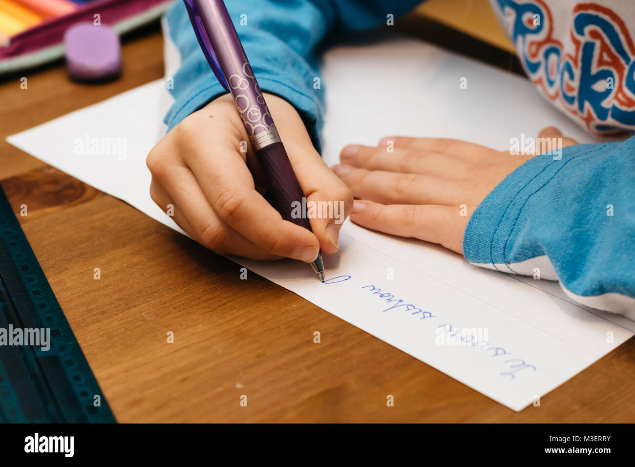Child doing homework. A young girl writes on paper and uses a pen Stock ...