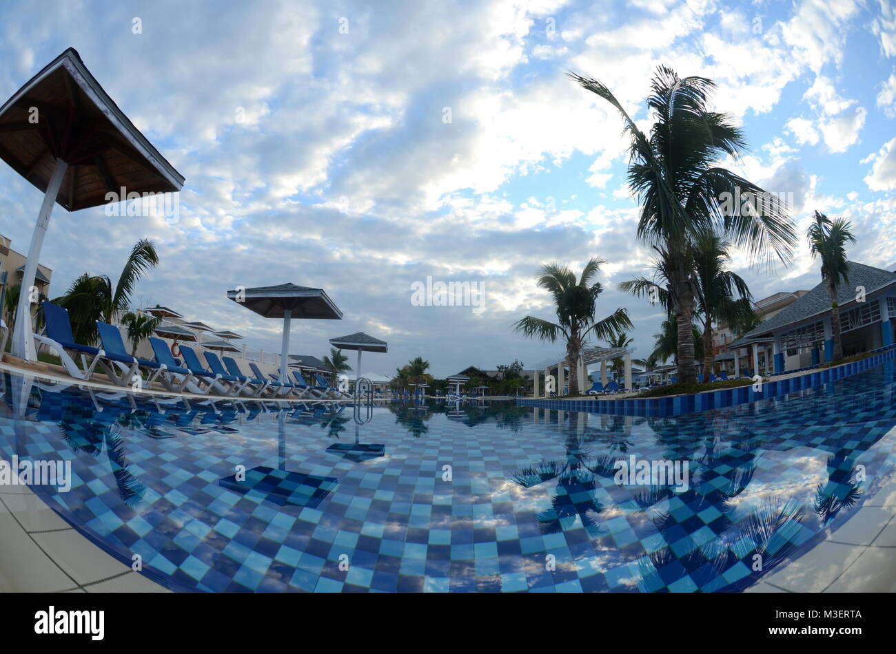 Early morning by the outdoor swimming pool in a popular vacation resort ...