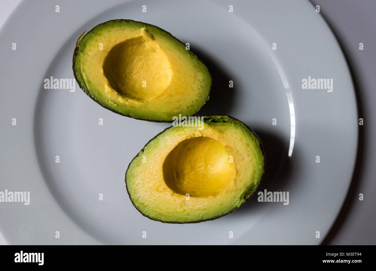 A fresh avocado cut in half Stock Photo - Alamy