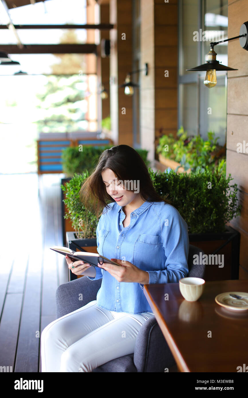 Beautiful girl reading diary at cafe Stock Photo - Alamy
