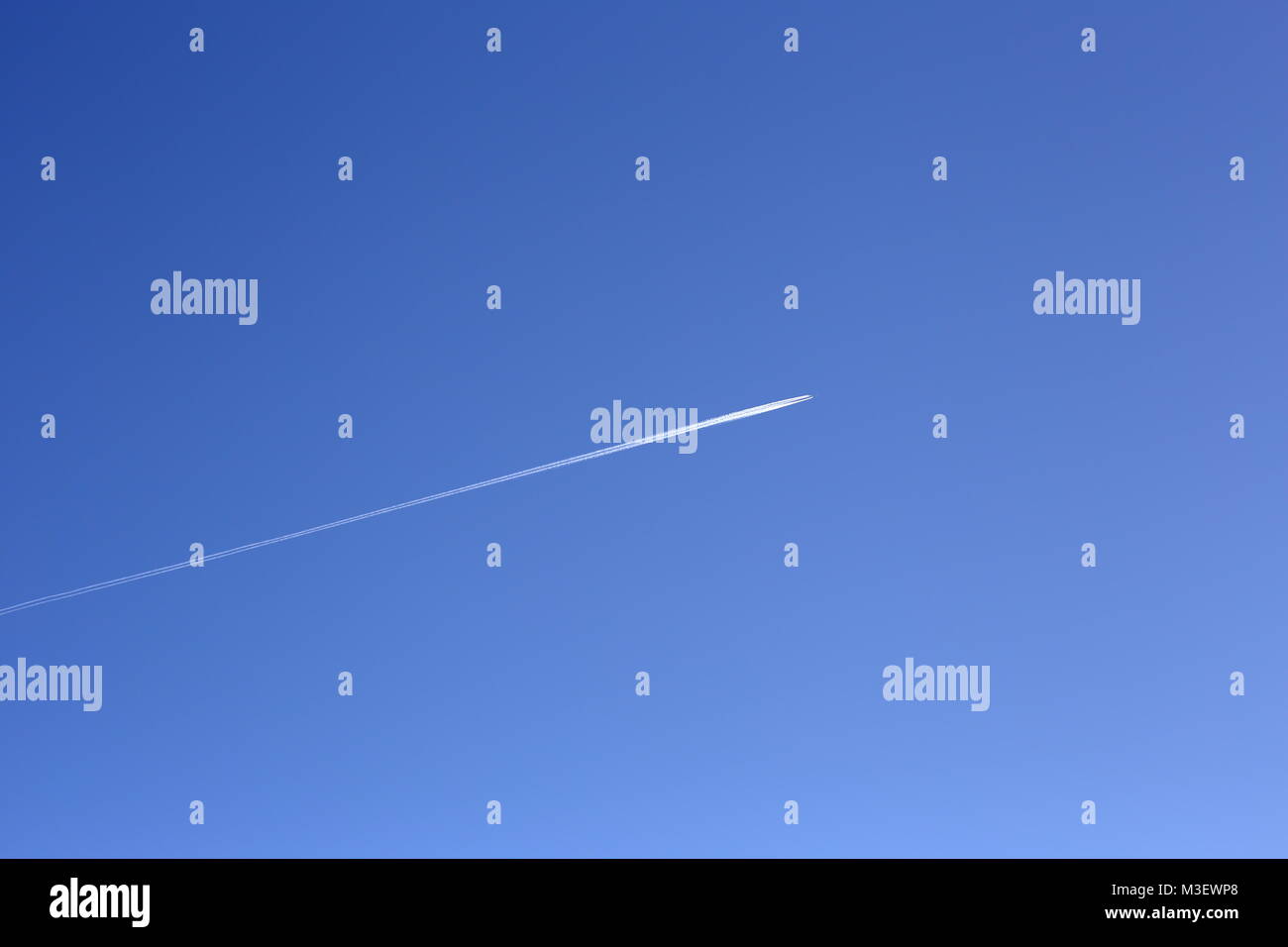 Vapor trail in a clear blue sky Stock Photo - Alamy